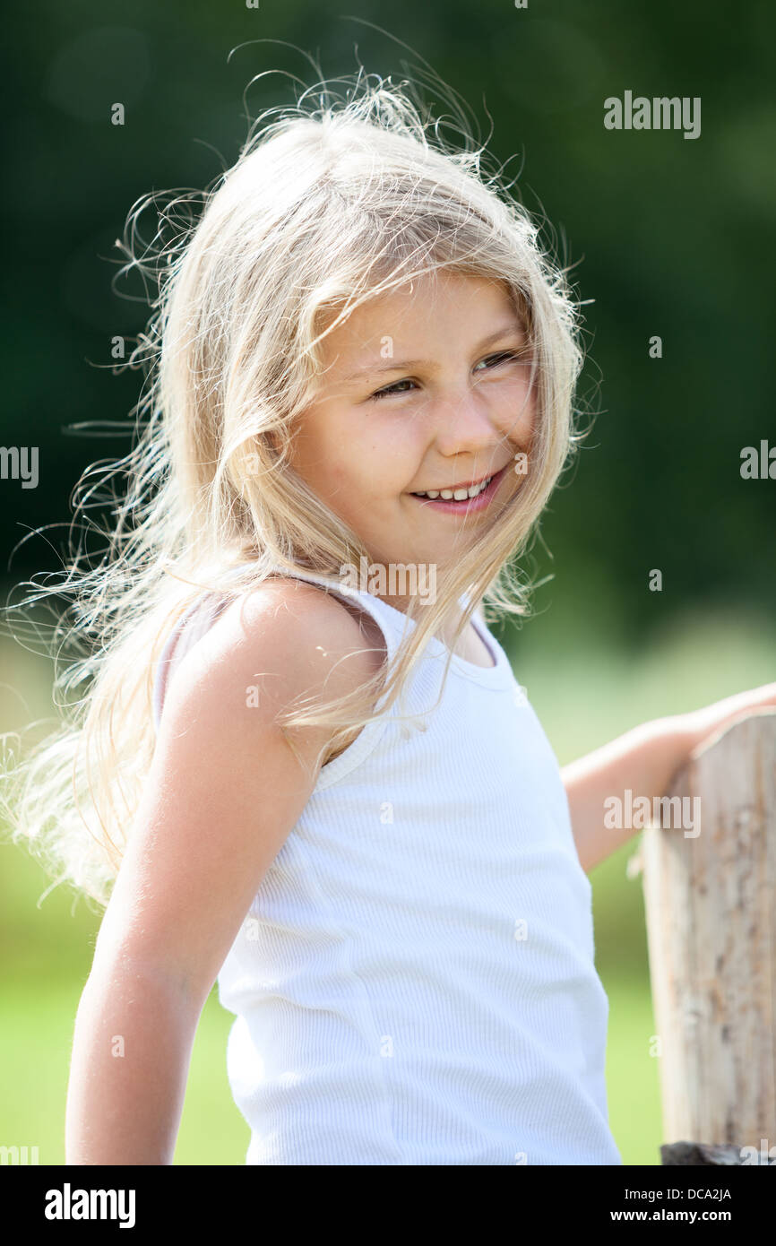 Toothy smiling beautiful Caucasian girl with blond hair at summer day ...