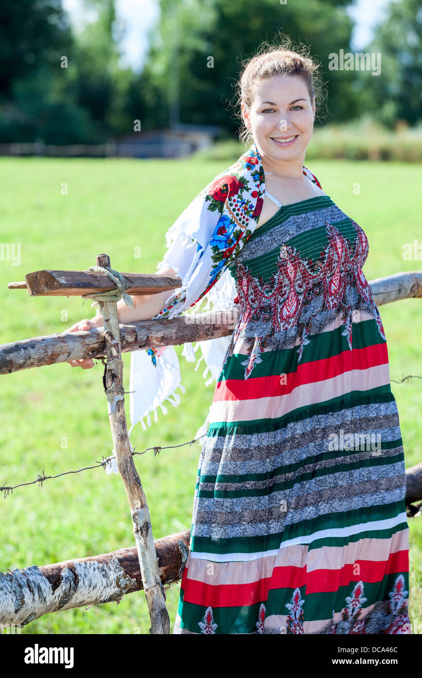 Posing country woman with rake on summer field. Russian people in rural ...