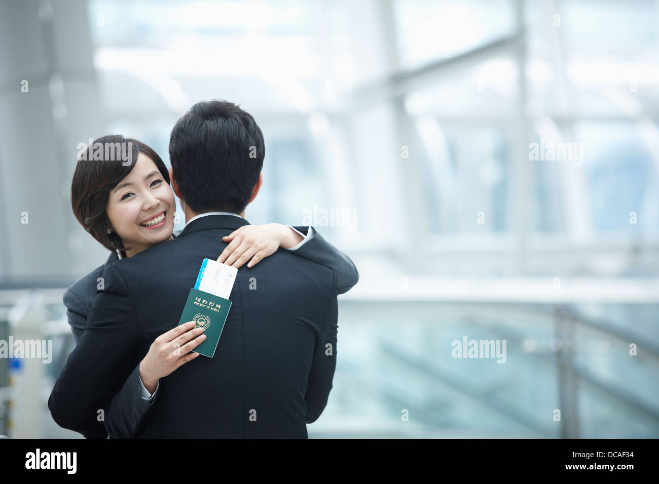 a businesswoman and businessman hugging each other in the airport Stock ...