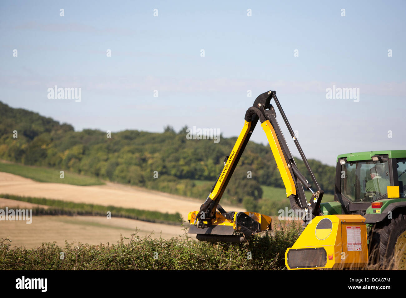 Green and Yellow John Deer tractor with hedge cutting arm in action ...