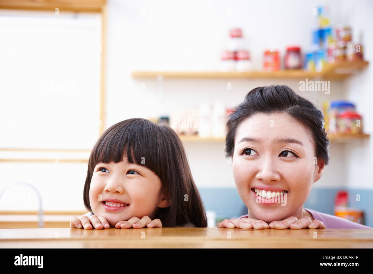 mother and daughter hiding behind table Stock Photo - Alamy