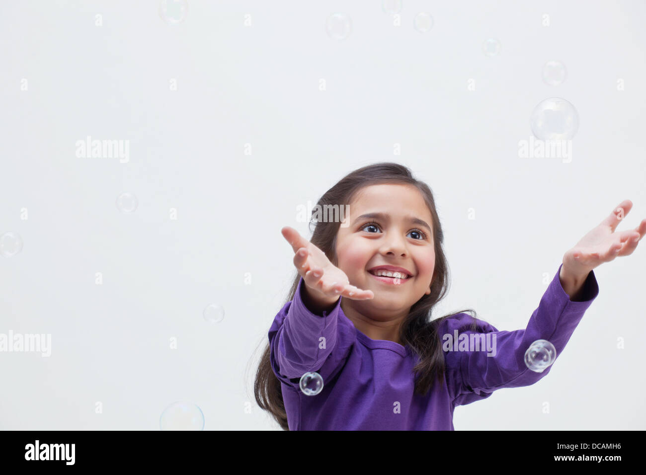Young girl trying to catch bubbles Stock Photo - Alamy