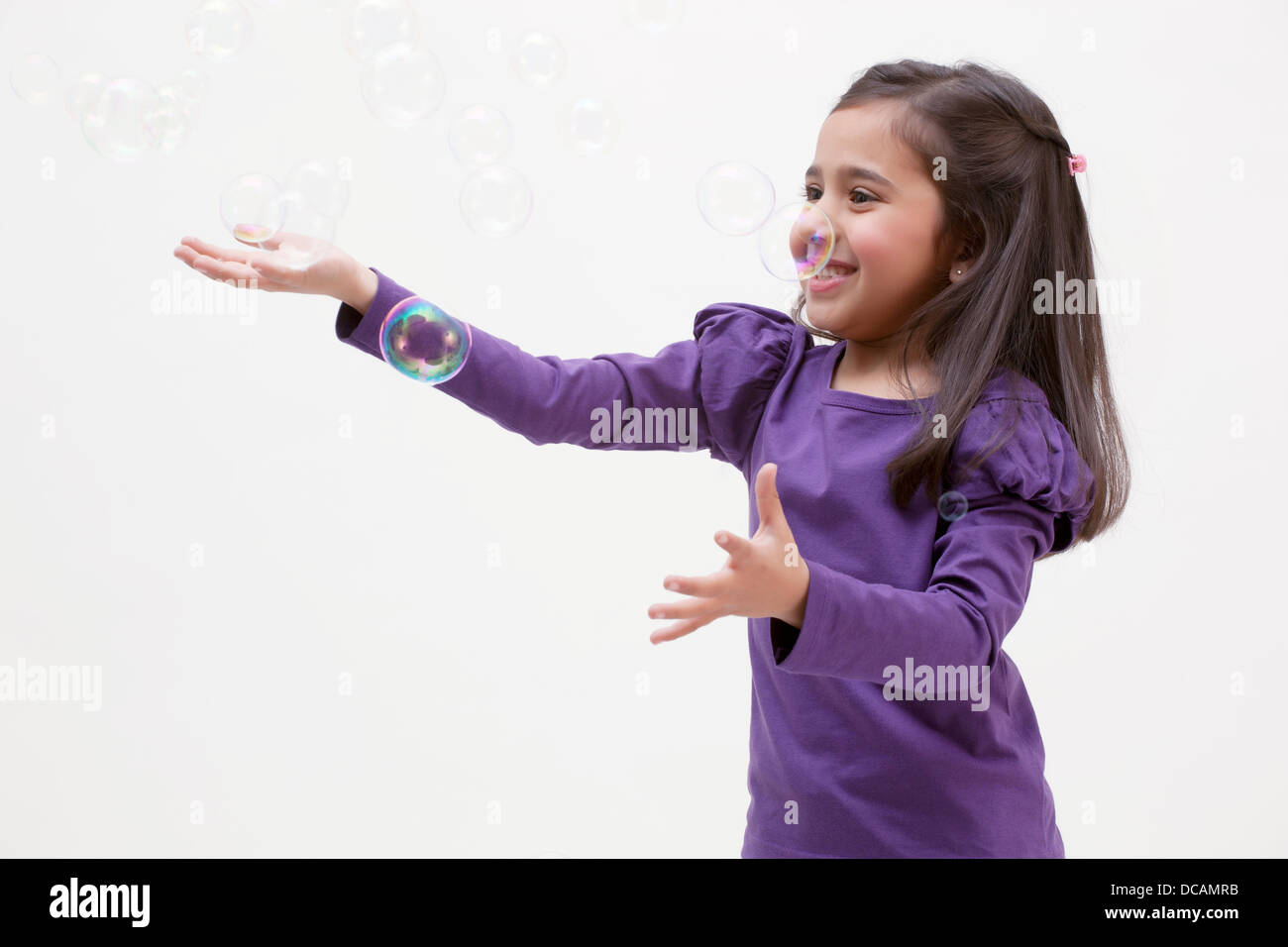 Young girl trying to catch bubbles Stock Photo - Alamy