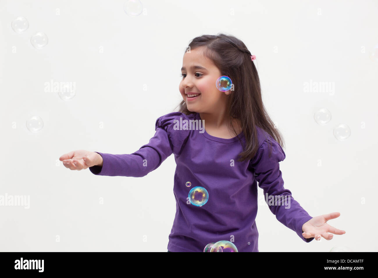 Young girl trying to catch bubbles hi-res stock photography and images ...