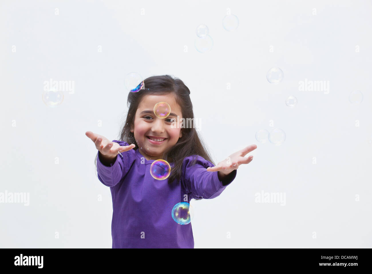 Young girl trying to catch bubbles Stock Photo - Alamy
