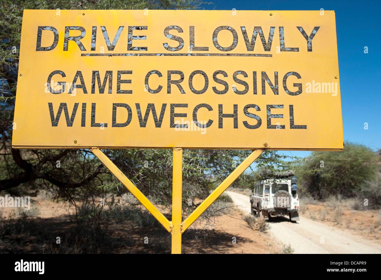 View of a sign in two languages urging the car driver to drive slowly ...