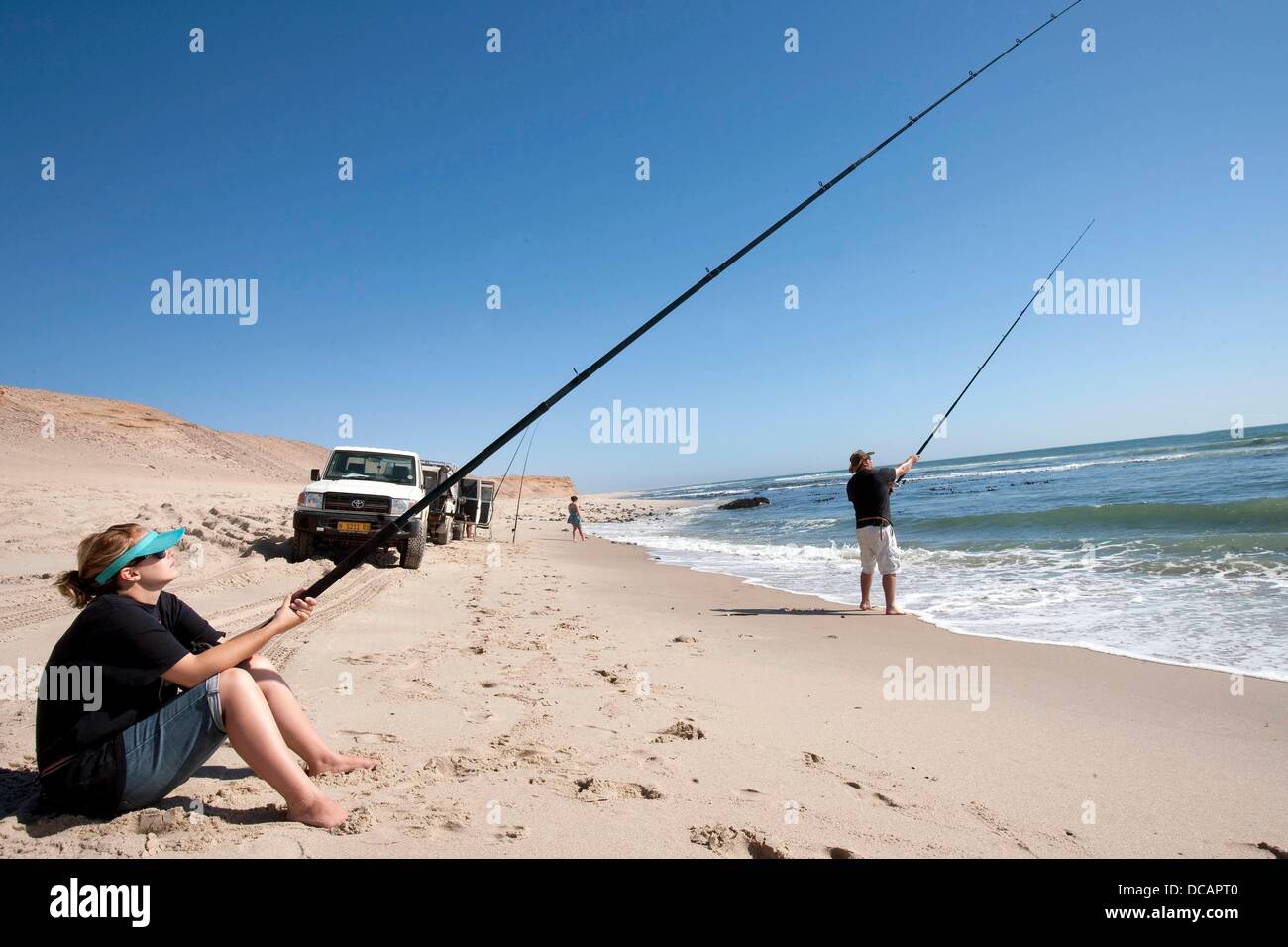 People are pictured fishing on the beach of the Atlantic Ocean near ...