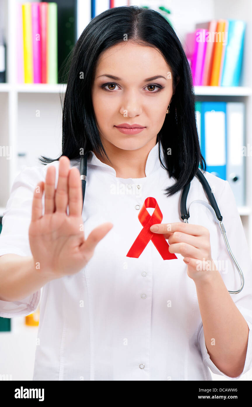 Female doctor holding a red ribbon as a symbol of AIDS Stock Photo - Alamy