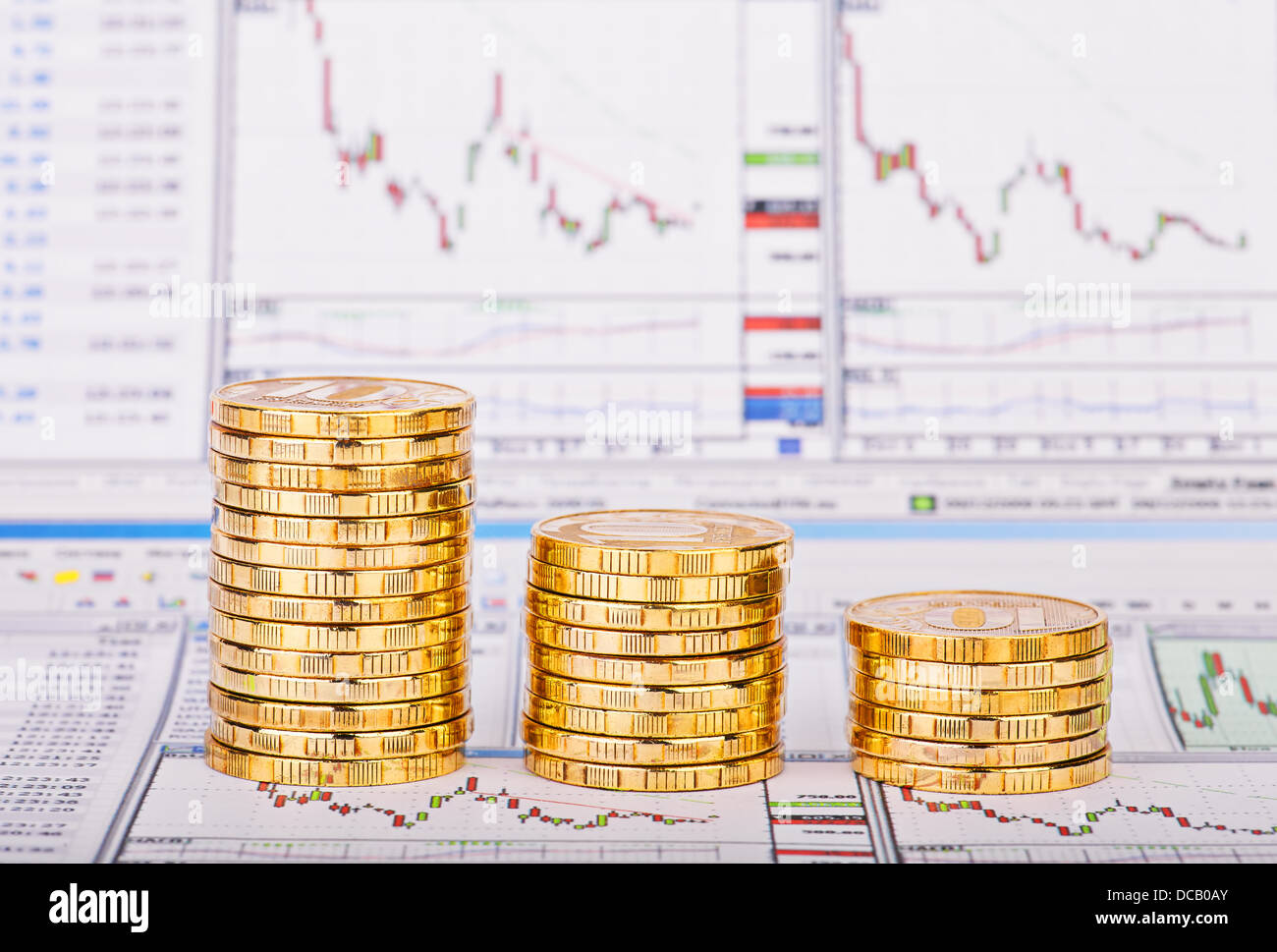 Down trend stacks of golden coins and financial chart as the background ...