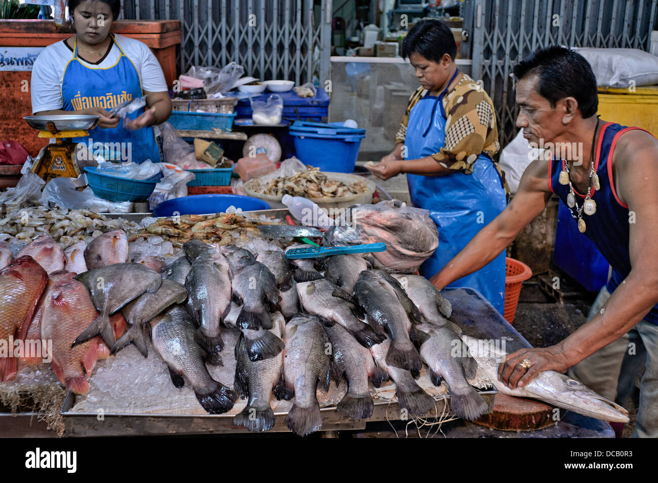Thailand fish market. Workers preparing fish for sale at an indoor ...