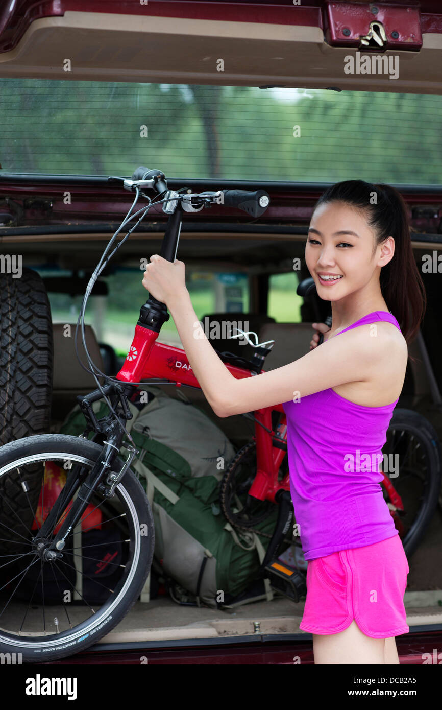 The young women taking the bicycle into the back of a car Stock Photo ...