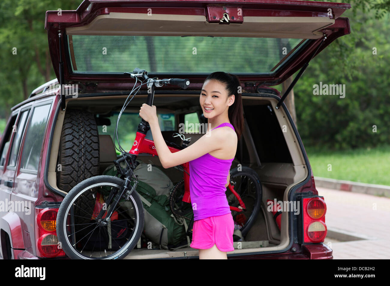 The young women taking the bicycle into the back of a car Stock Photo ...