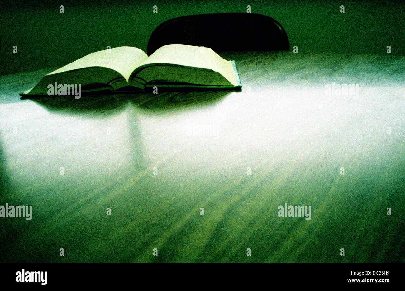 Open book at empty table Stock Photo - Alamy