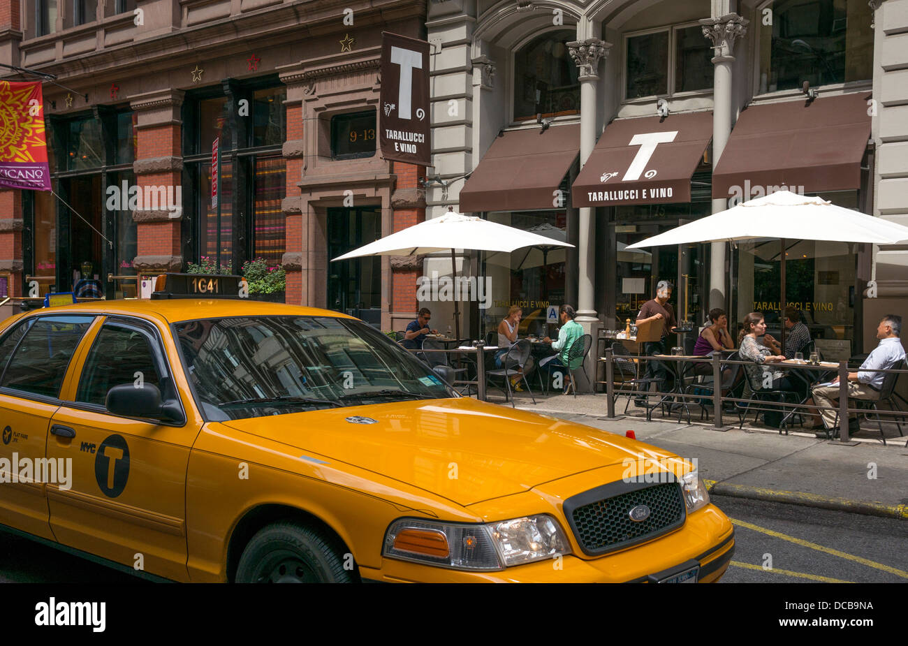Yellow taxicab passes alfresco Italian restaurant Stock Photo - Alamy