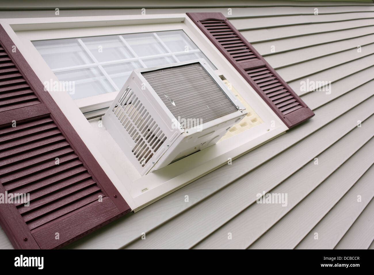 Air conditioner in house window with gray siding Stock Photo - Alamy