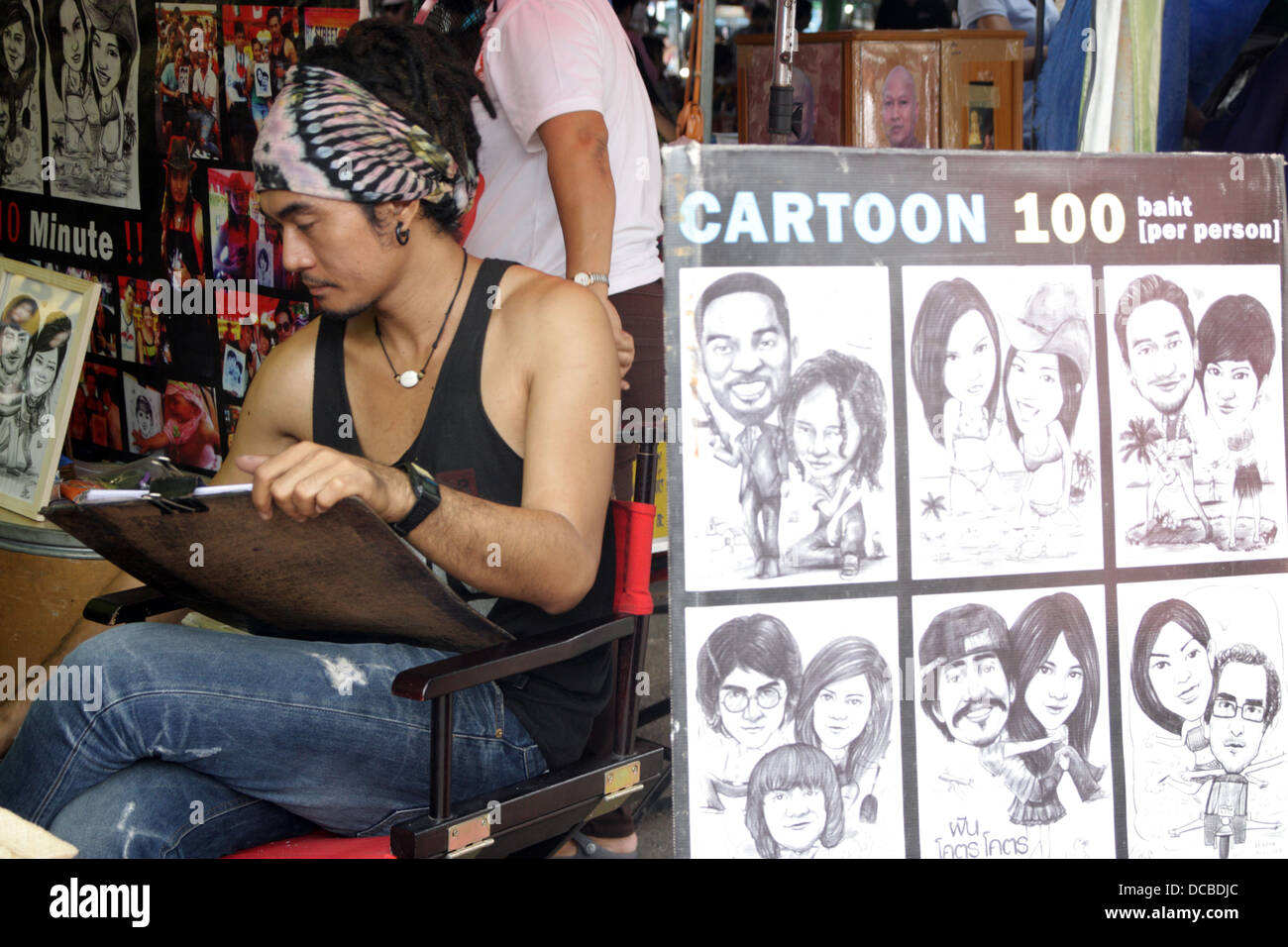 Artist drawing portrait for customer in shop at Chatuchak Weekend ...