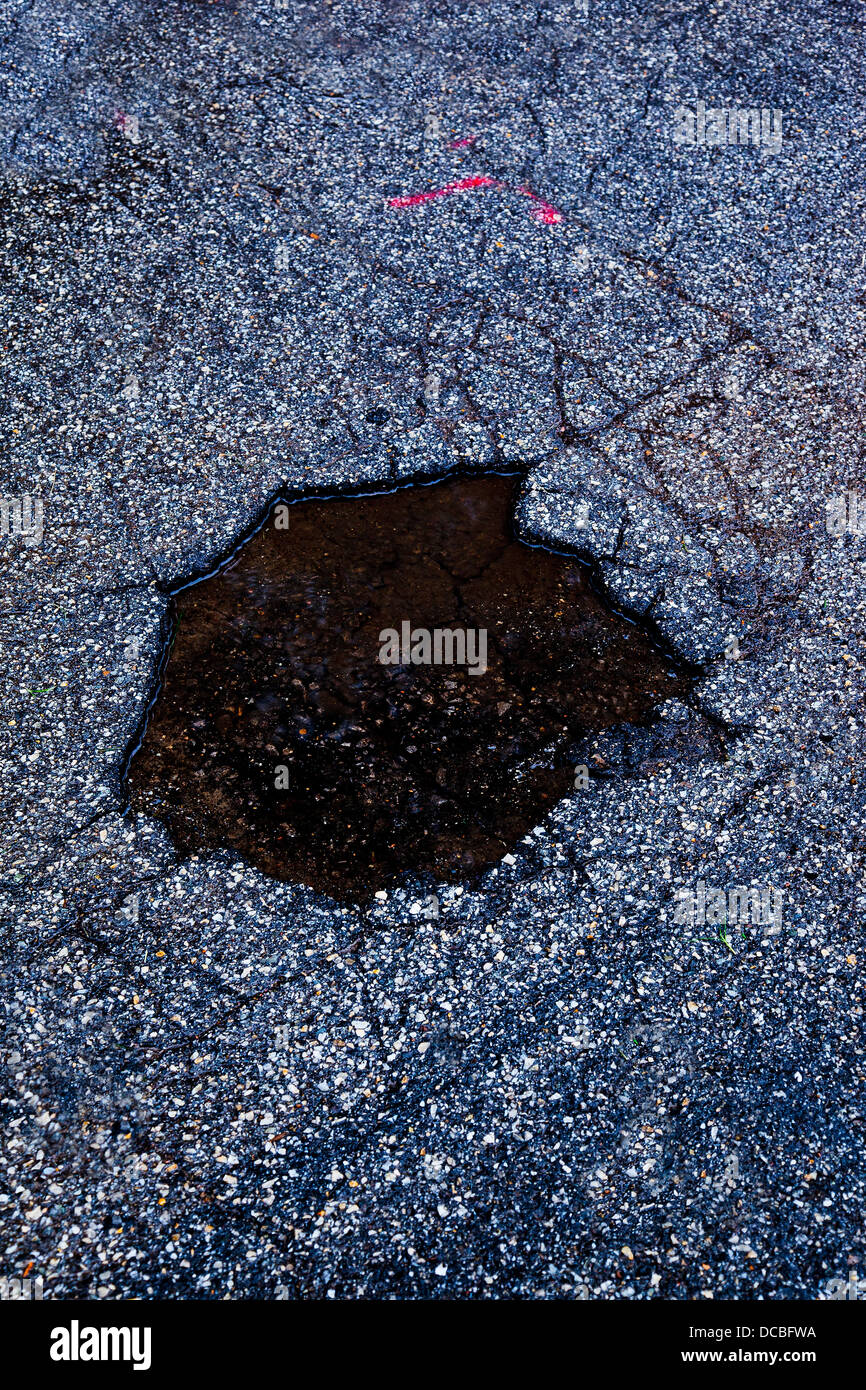 Pothole in road, filled with water Stock Photo - Alamy