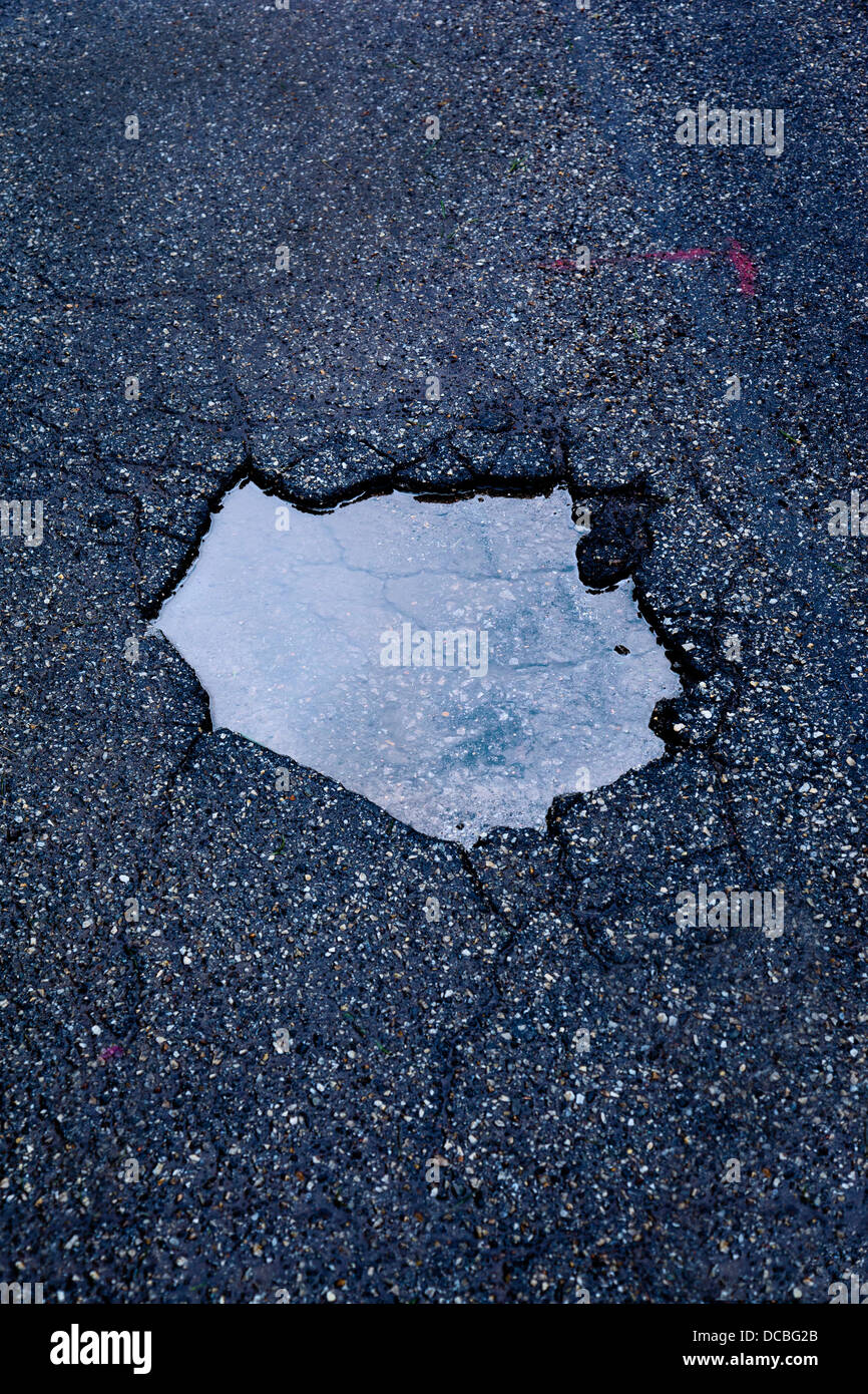 Pothole in road, filled with water Stock Photo - Alamy