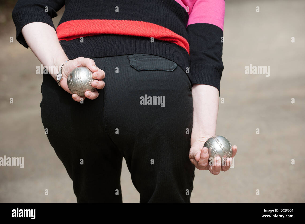 Woman playing boules holding the metal balls used in this popular ...