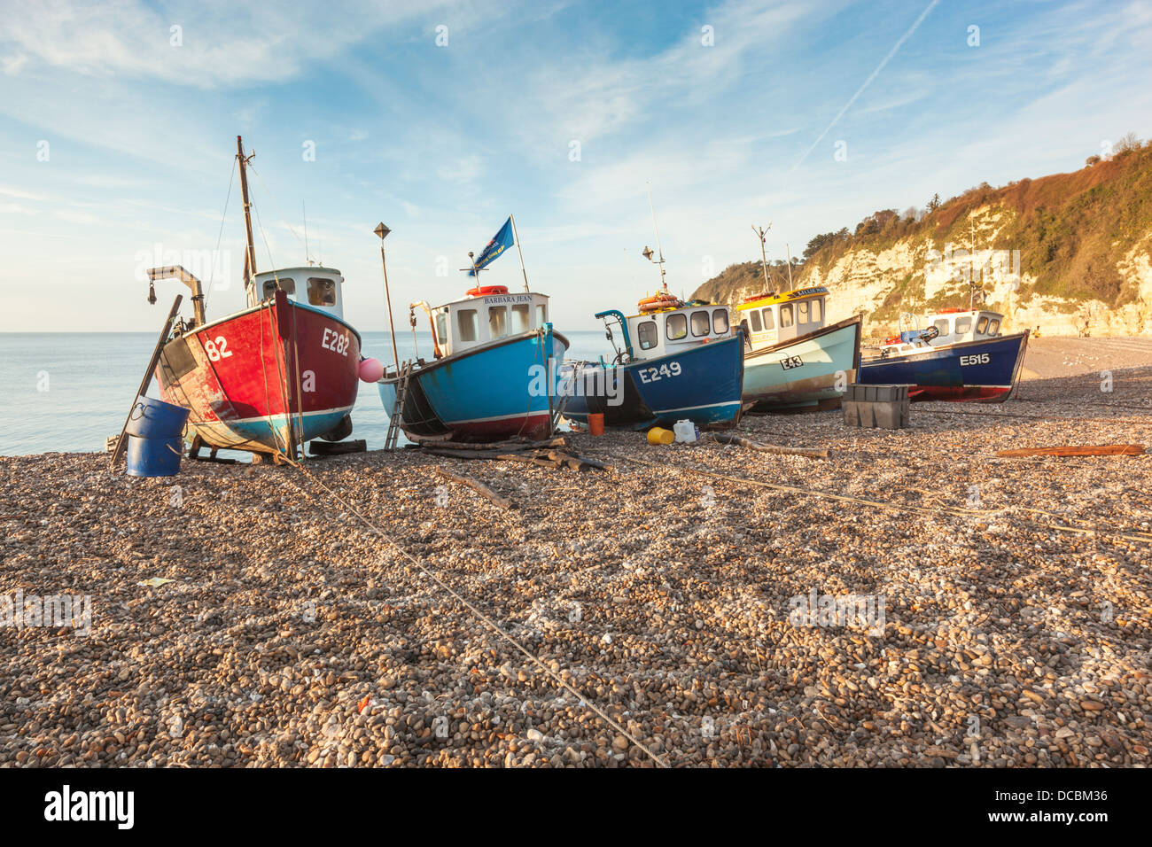 Row of painted fishing boats on pebbly beach at Beer, Devon Stock Photo ...