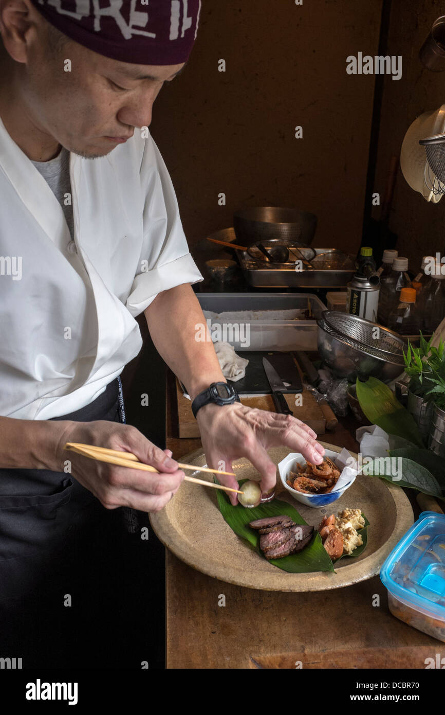 Japanese chef preparing traditional Japanese food in a traditional ...