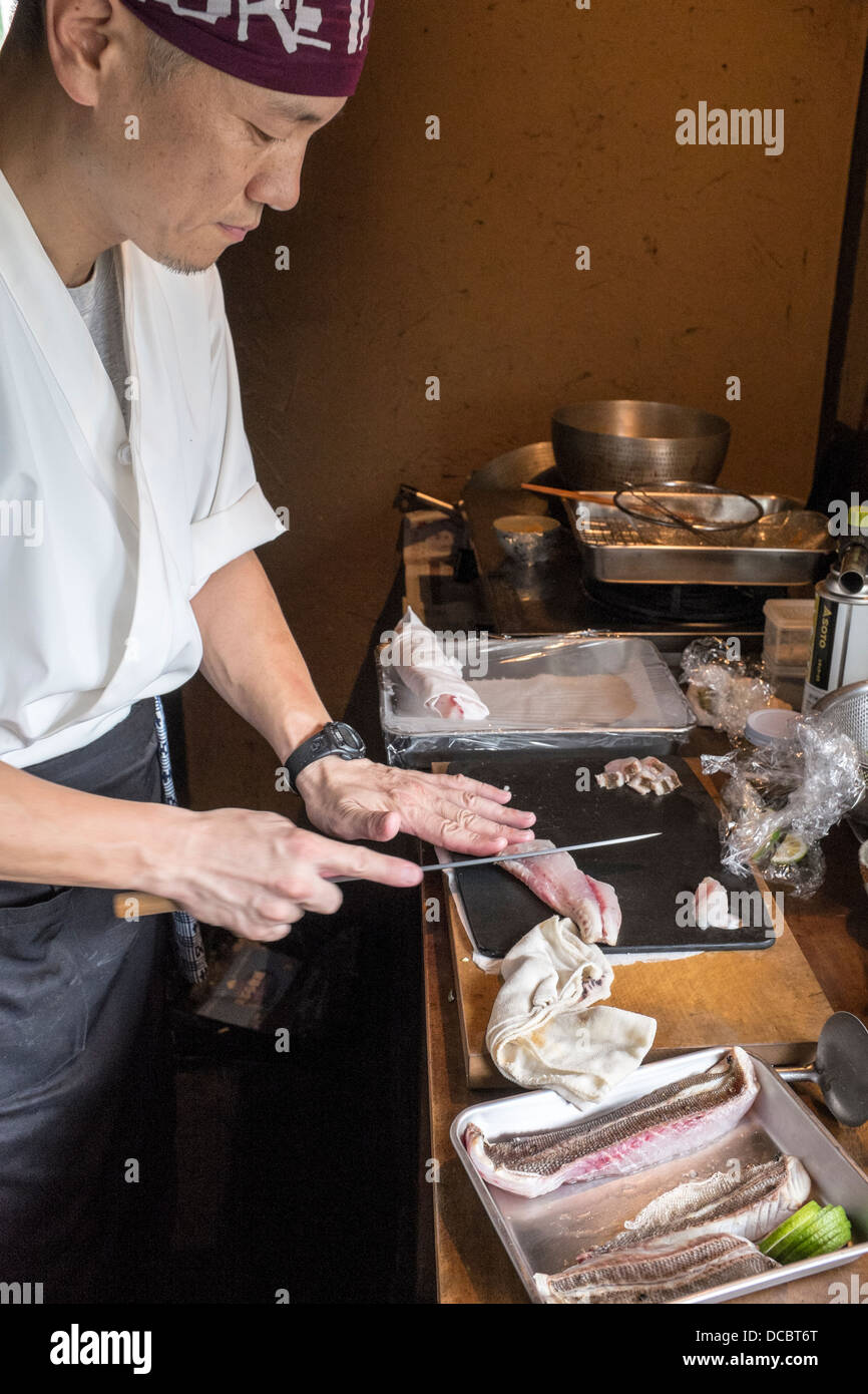 Japanese chef preparing traditional Japanese food in a traditional ...