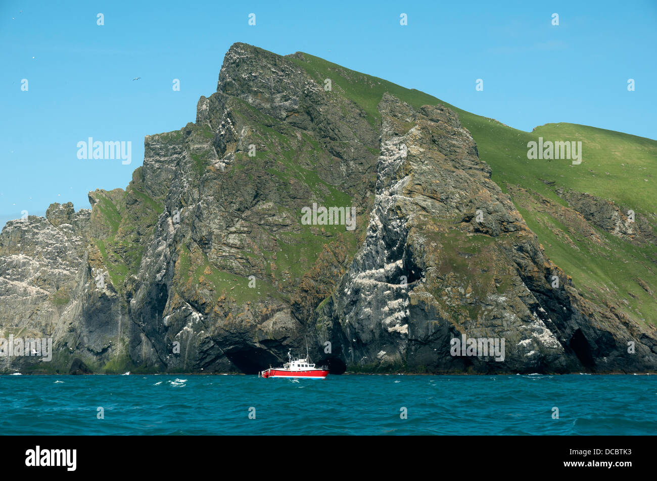 Tourist boat below cliffs off the island of Boreray, St Kilda ...