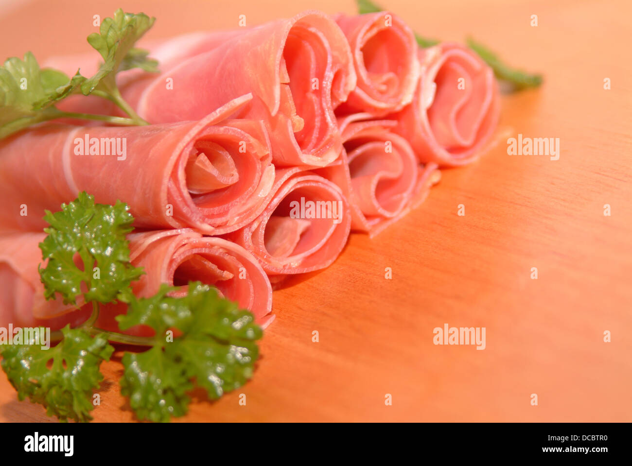 sliced ham rolled on a timber plate Stock Photo - Alamy