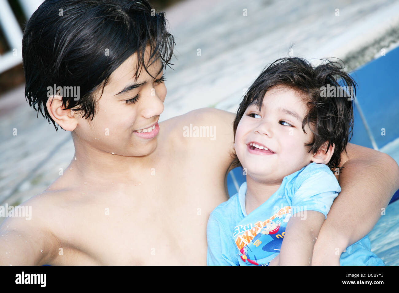 Big brother taking care of baby brother Stock Photo - Alamy