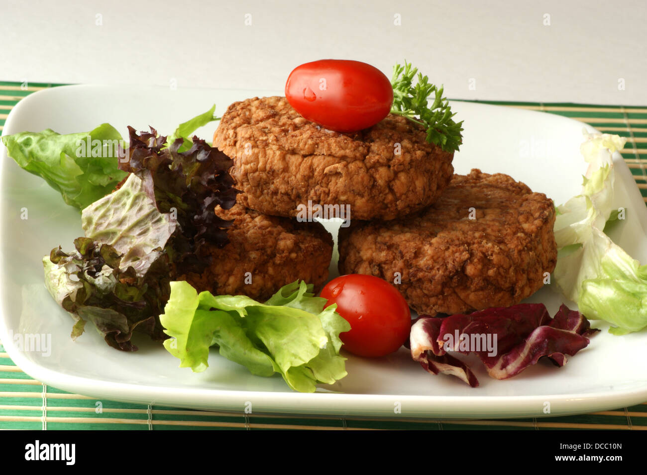 rissole with plum tomato and salad on a plate Stock Photo - Alamy