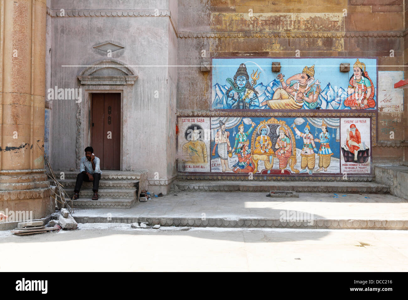 A man uses his cell phone outside a temple in Varanasi, India Stock ...