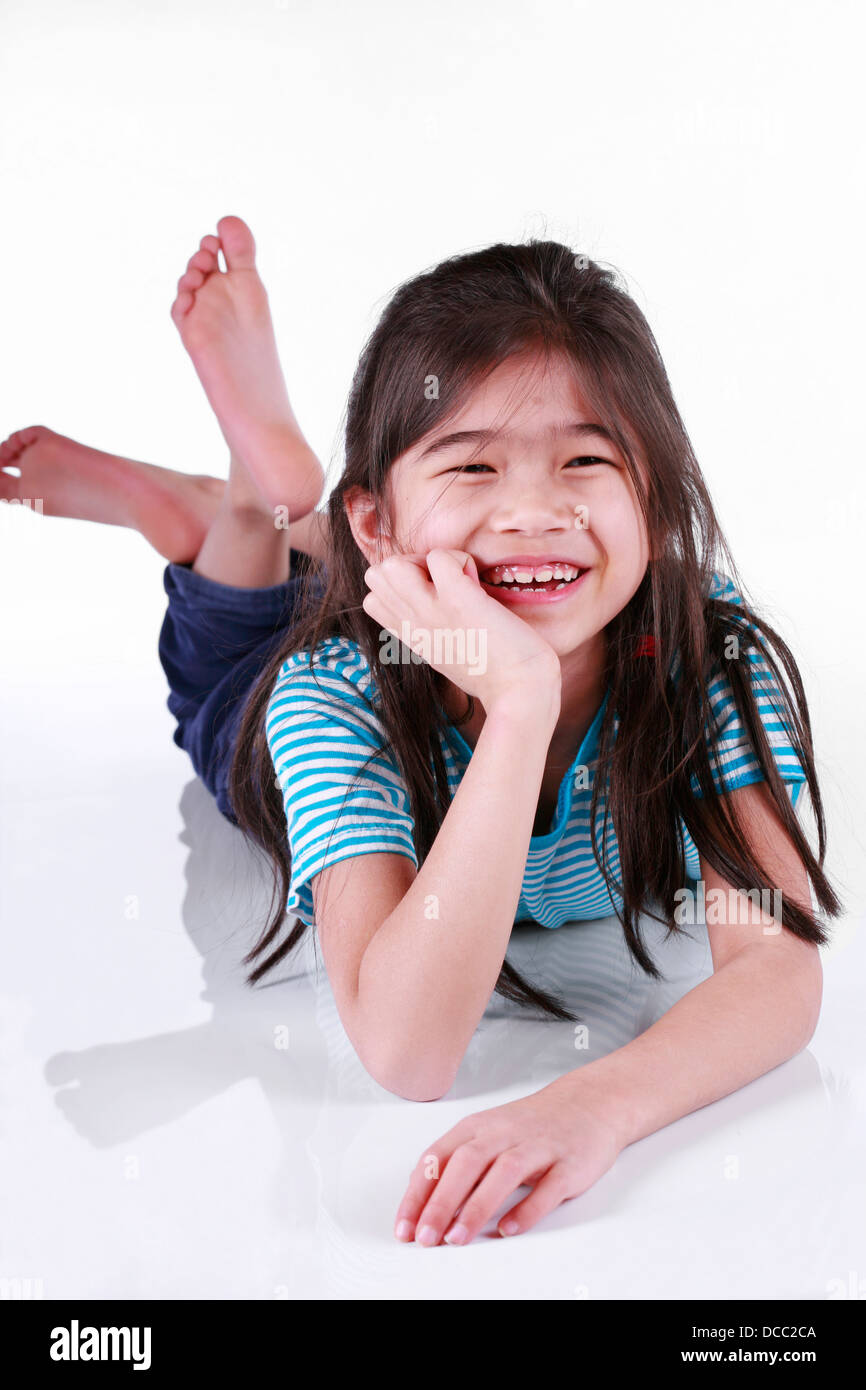 Happy little girl lying on floor Stock Photo - Alamy