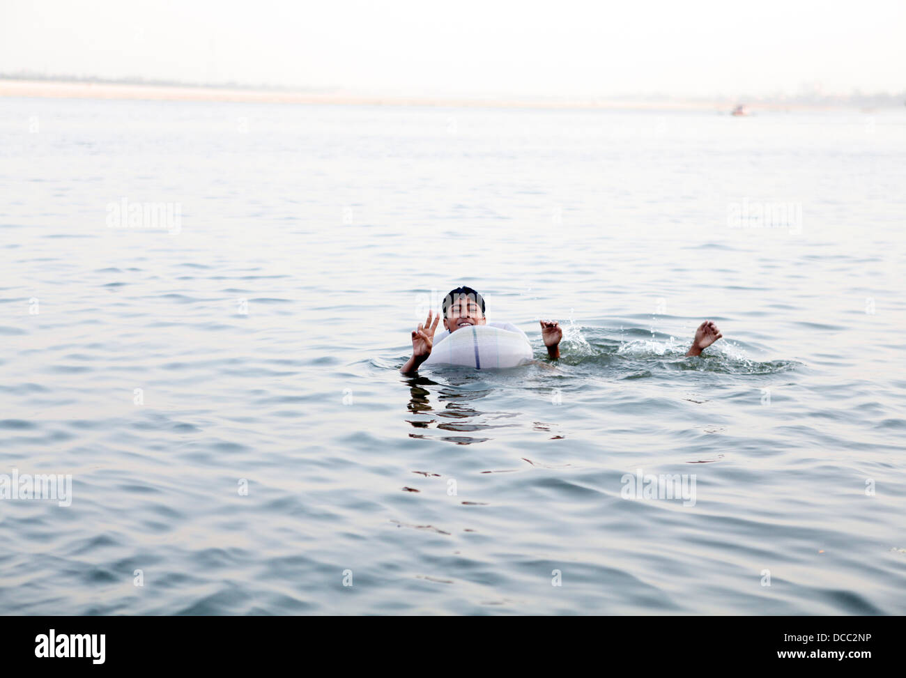 A teenage boy poses for the camera while playing in the River Ganges ...