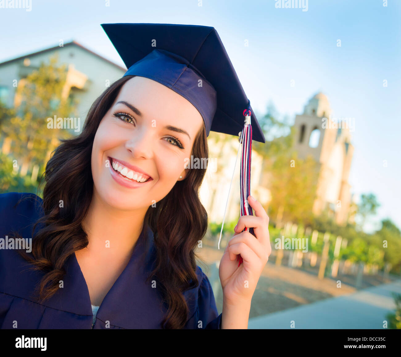 Happy Graduating Mixed Race Woman In Cap and Gown Celebrating on Campus ...