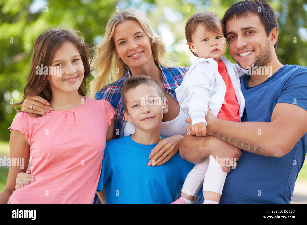 Photo of happy family looking at camera outdoors Stock Photo - Alamy