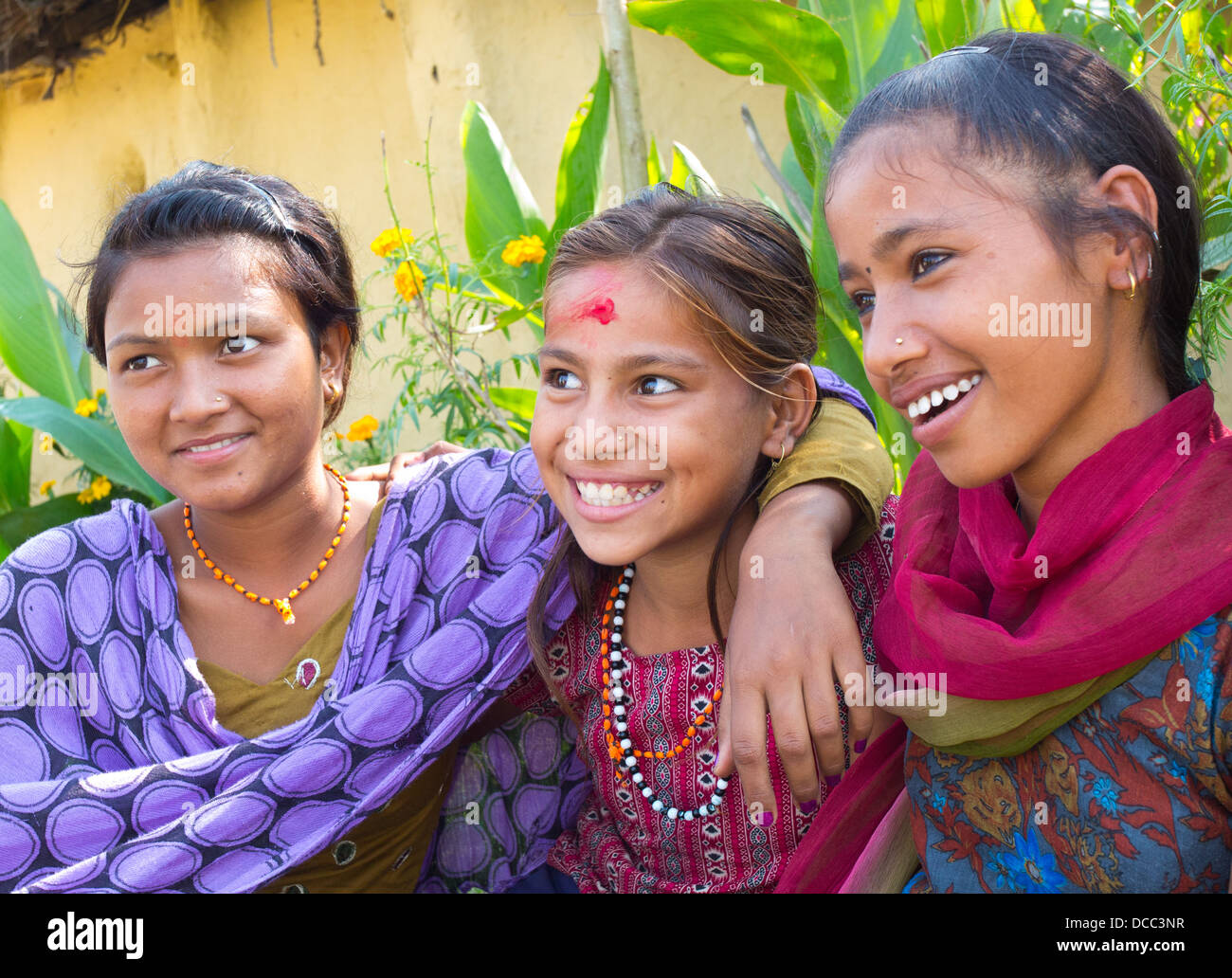 Three happy young Nepalese girls smiling in a rural Terai village ...