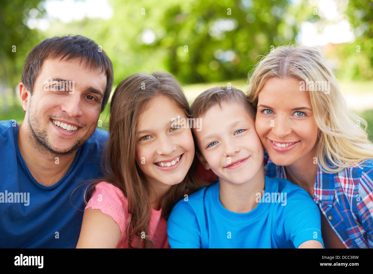 Photo of happy family of four looking at camera outdoors Stock Photo ...