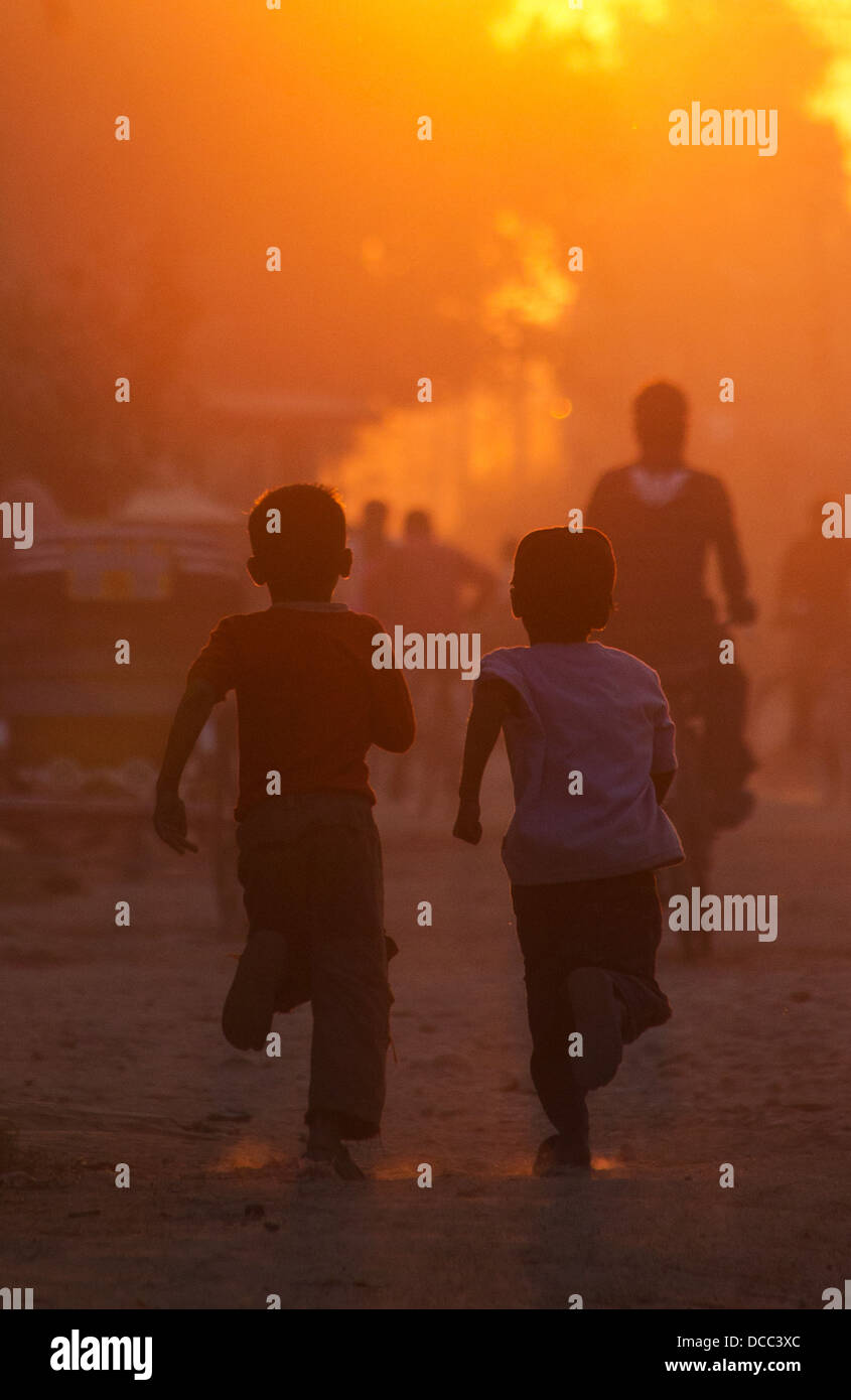 Two boys running on a street at sunset, Nepalganj, Nepal Stock Photo ...