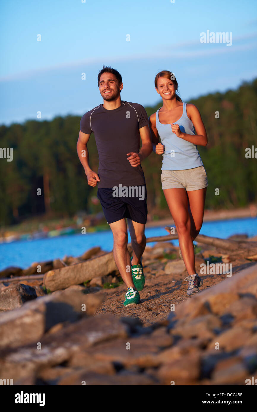 Photo of happy young couple running outdoors Stock Photo - Alamy