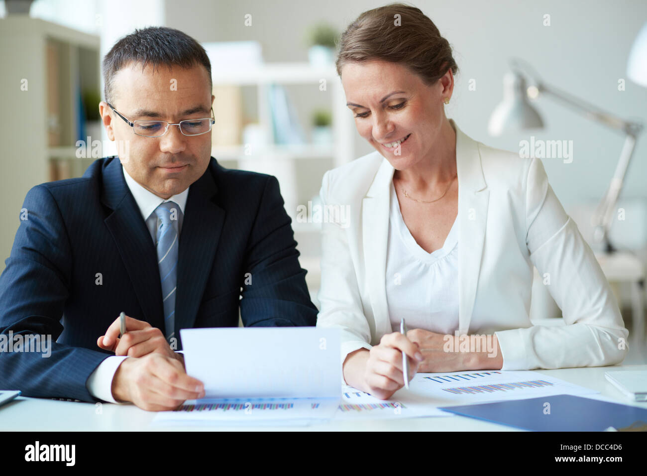 Two mature business partners looking at document in office Stock Photo ...