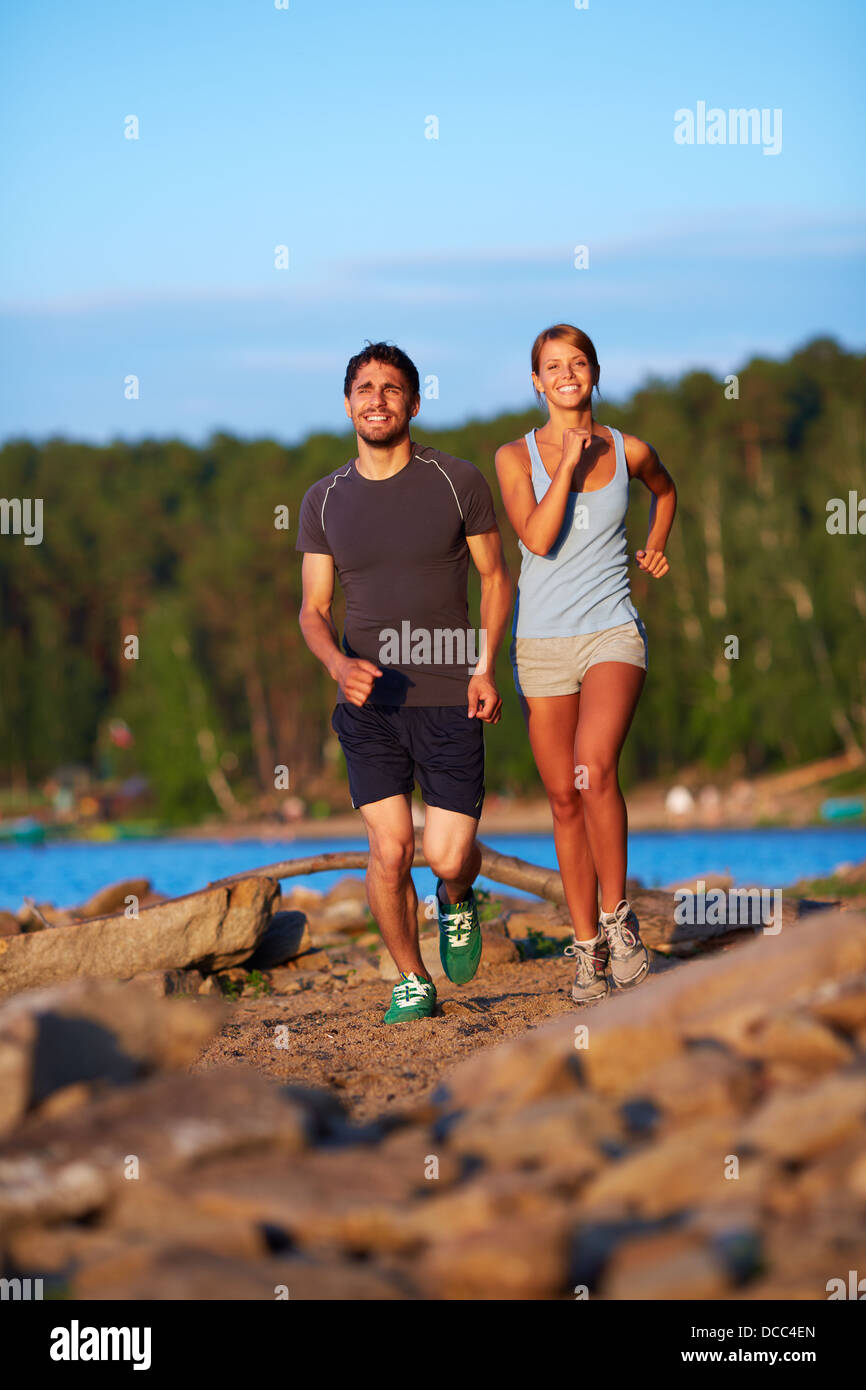 Photo of happy couple running outdoors Stock Photo - Alamy