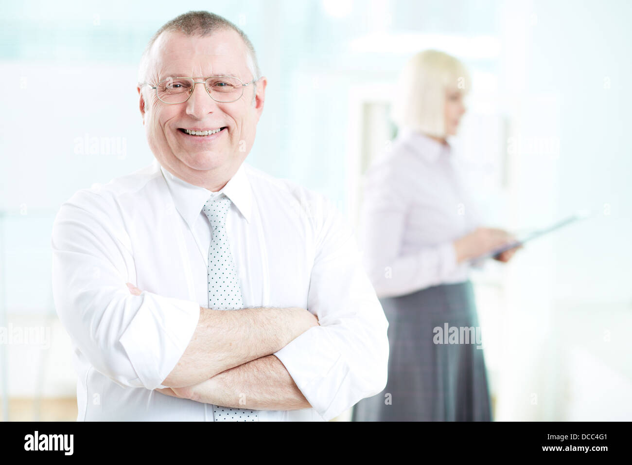 Portrait of smiling boss looking at camera with female standing on ...