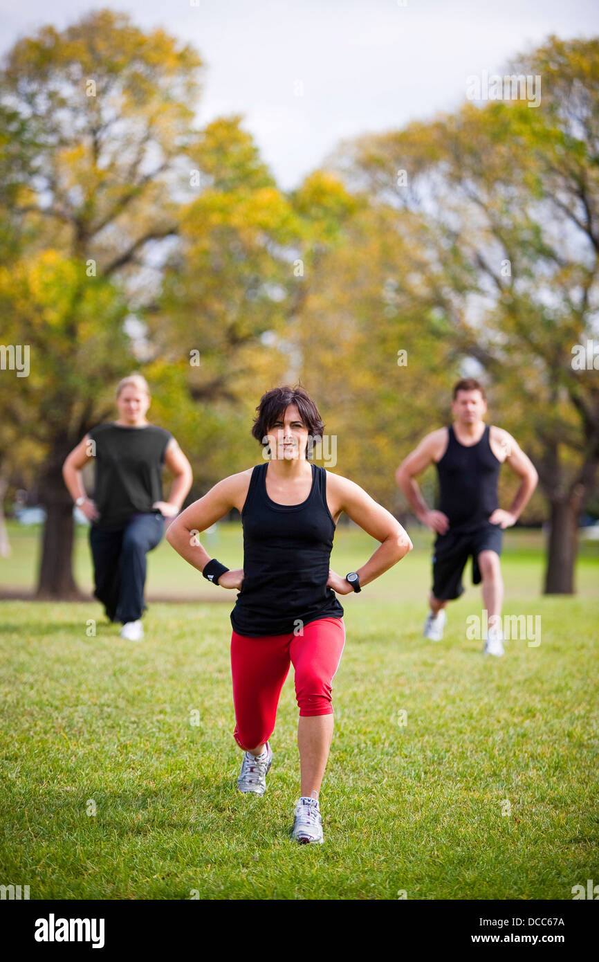 Healthy man and women working out with female fitness instructor ...