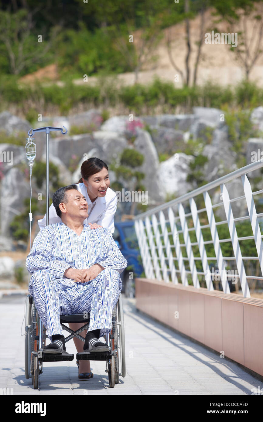female doctor pushing a patient in a wheel chair Stock Photo - Alamy