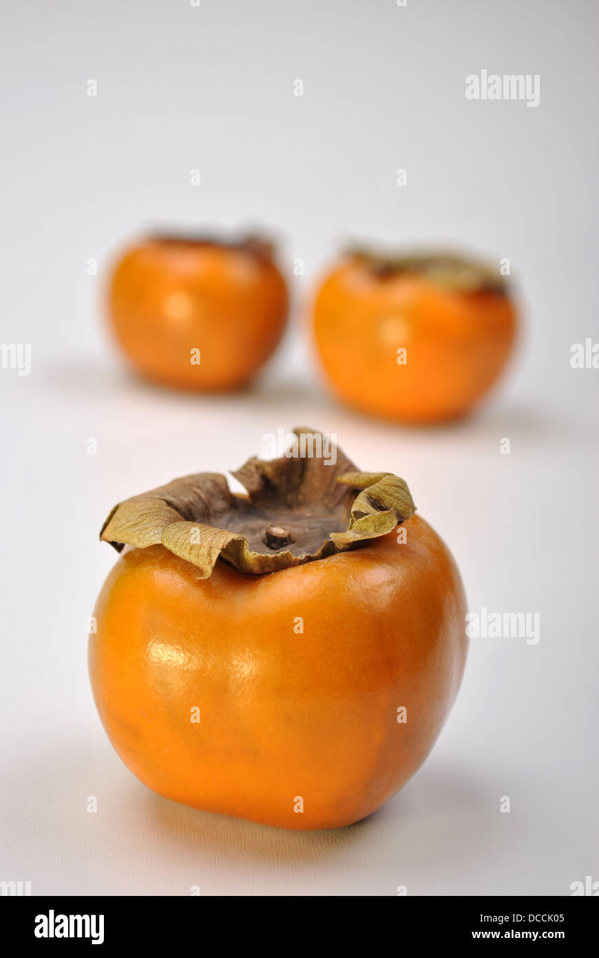 some organic sharon fruit and a white background Stock Photo - Alamy