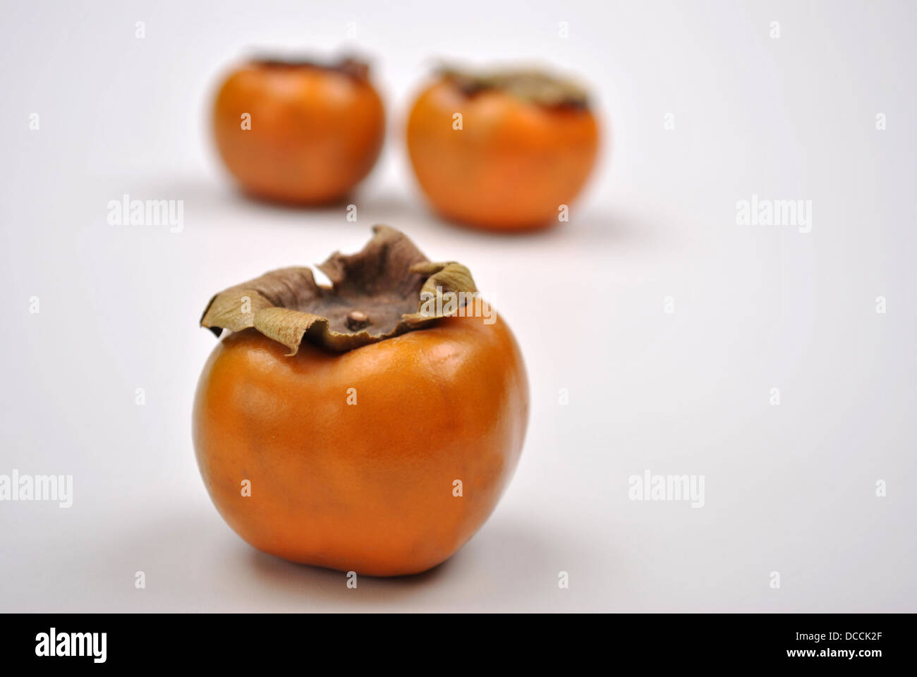 organic sharon fruit and a white background Stock Photo - Alamy