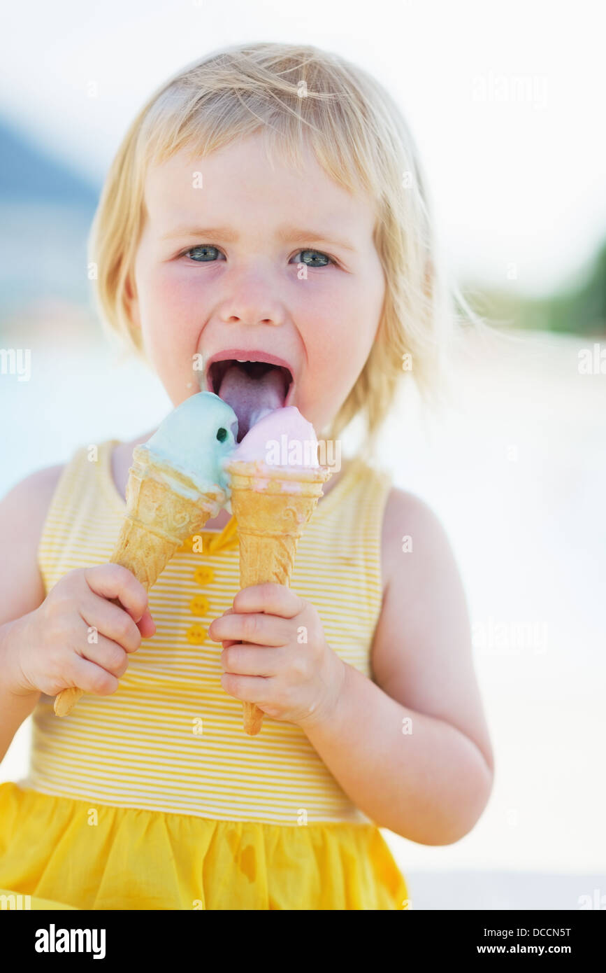 Happy baby eating two ice cream Stock Photo - Alamy