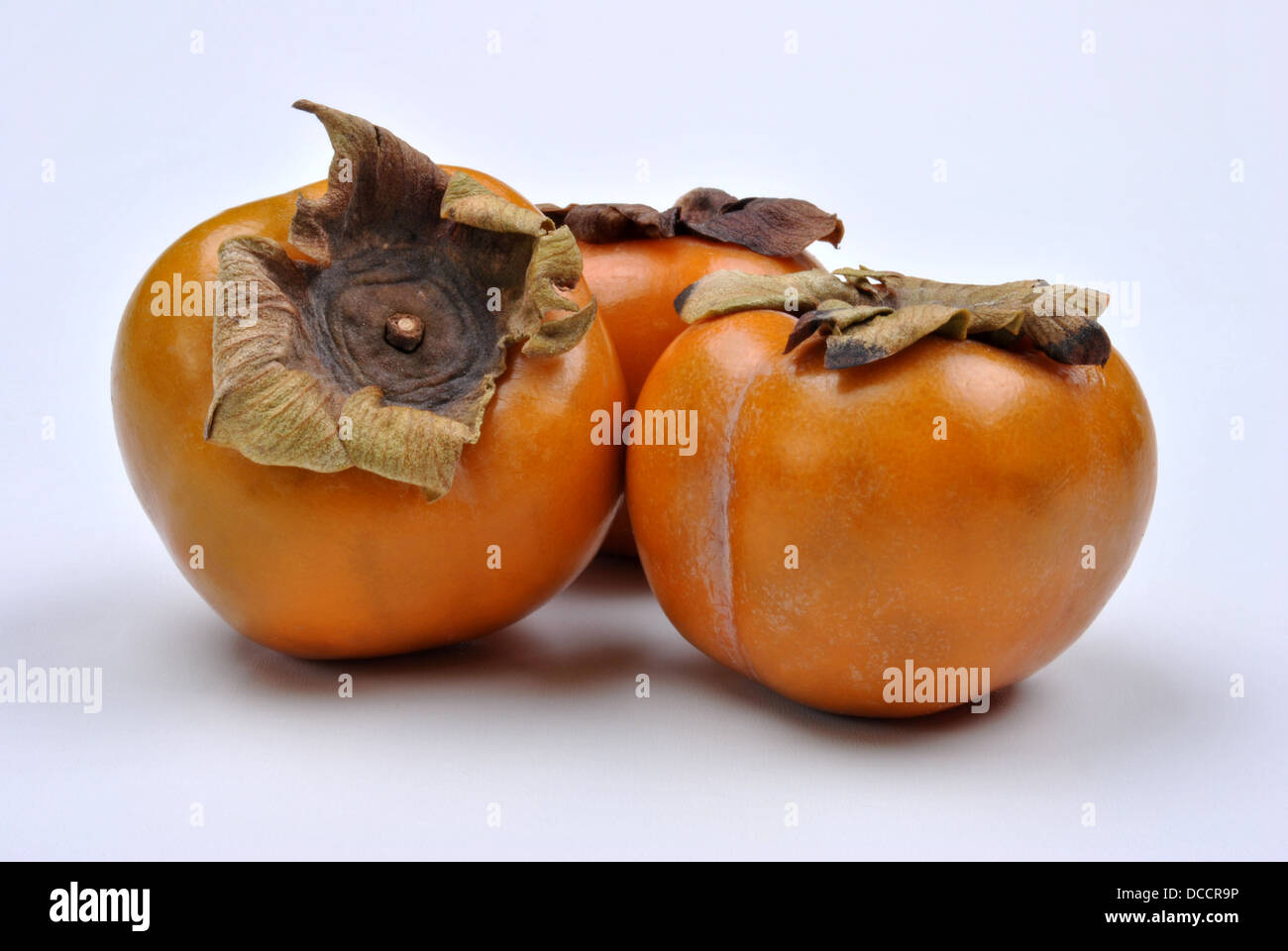 organic sharon fruit and a white background Stock Photo - Alamy