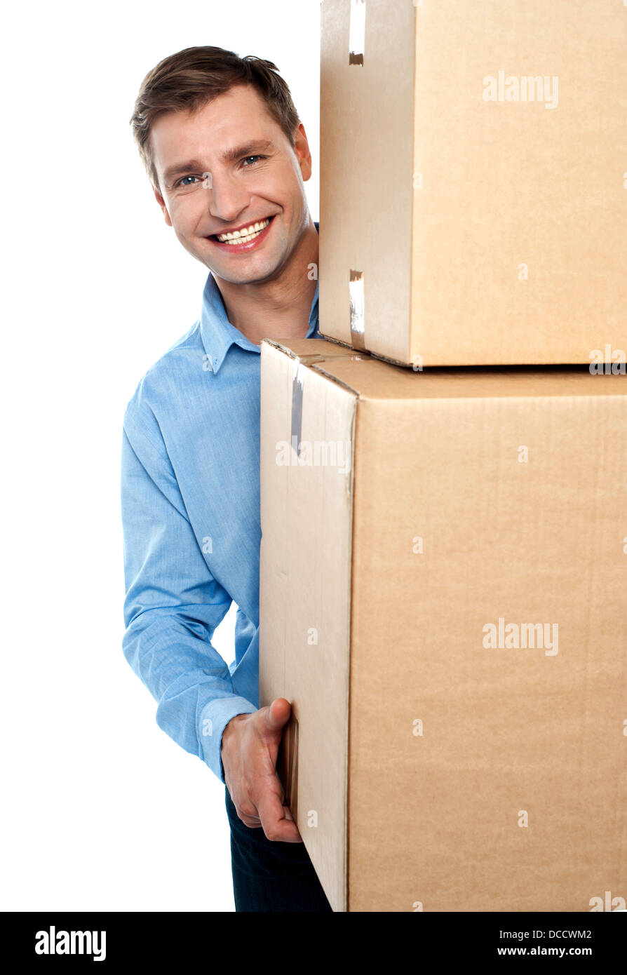 Smiling young man holding cardboard boxes isolated on white background ...