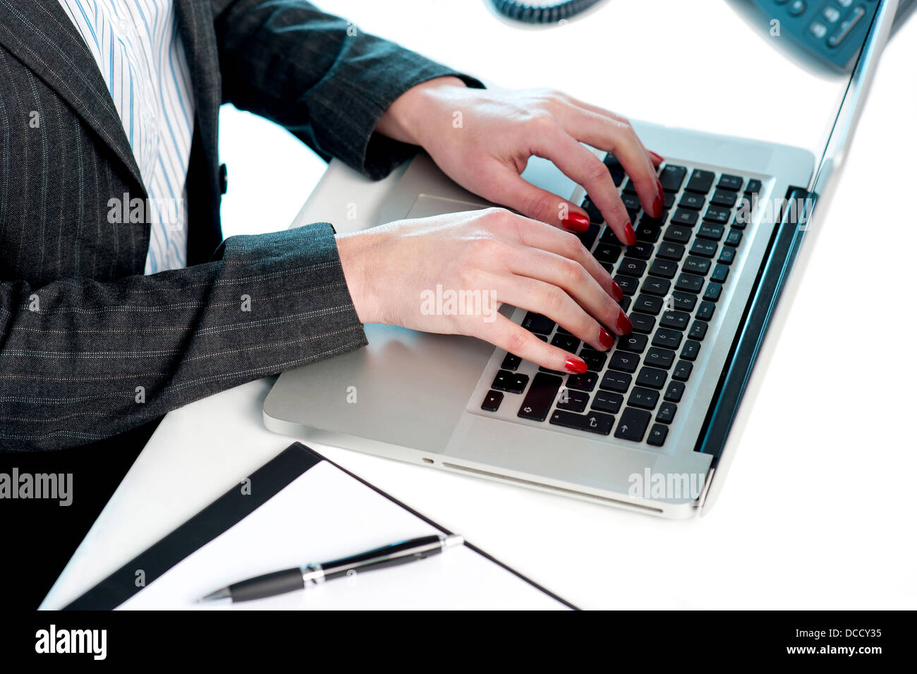 Females hands typing on laptop keypad. Cropped image. Busy office desk ...